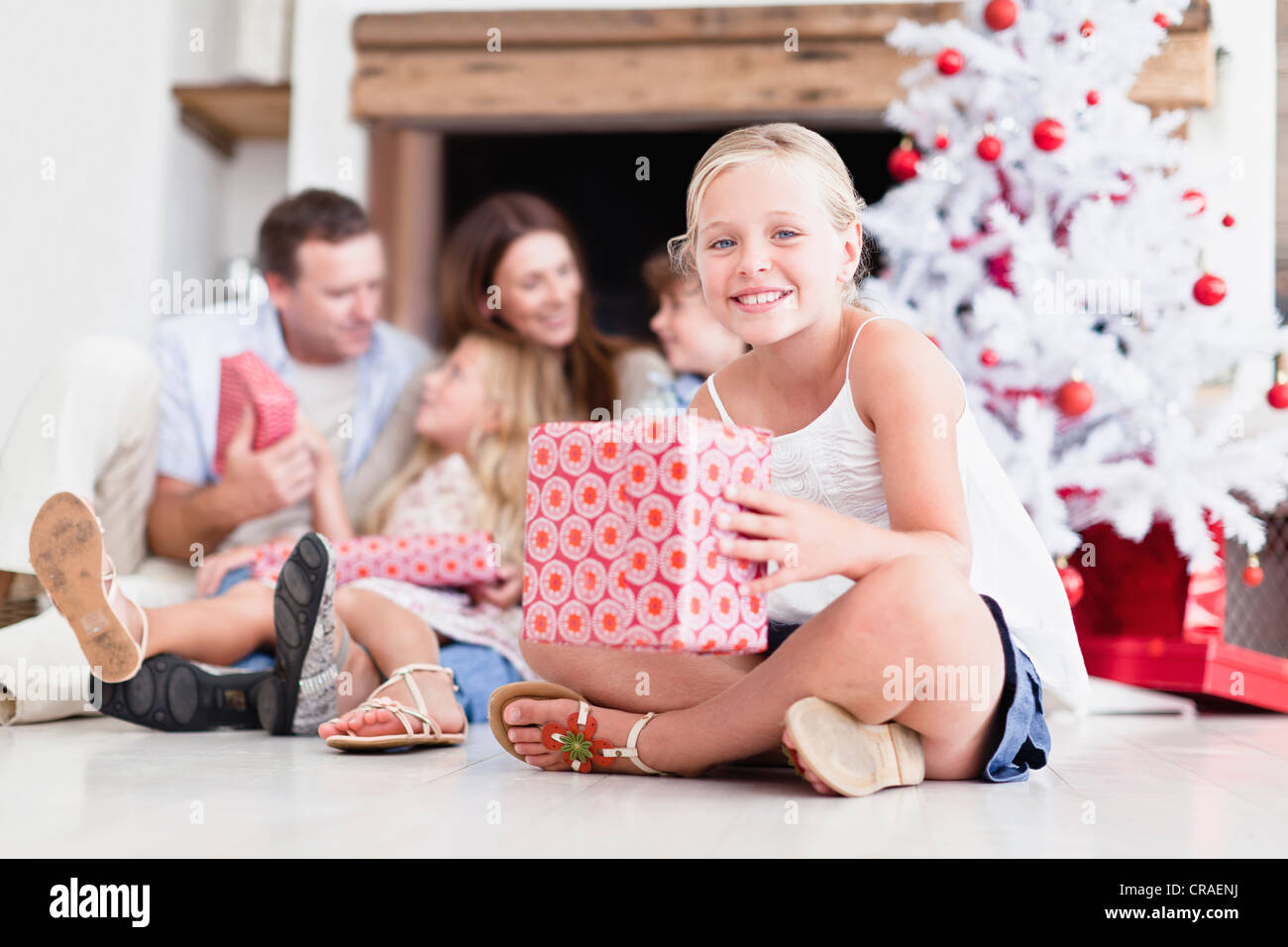 Girl sitting with wrapped Christmas gift Stock Photo - Alamy