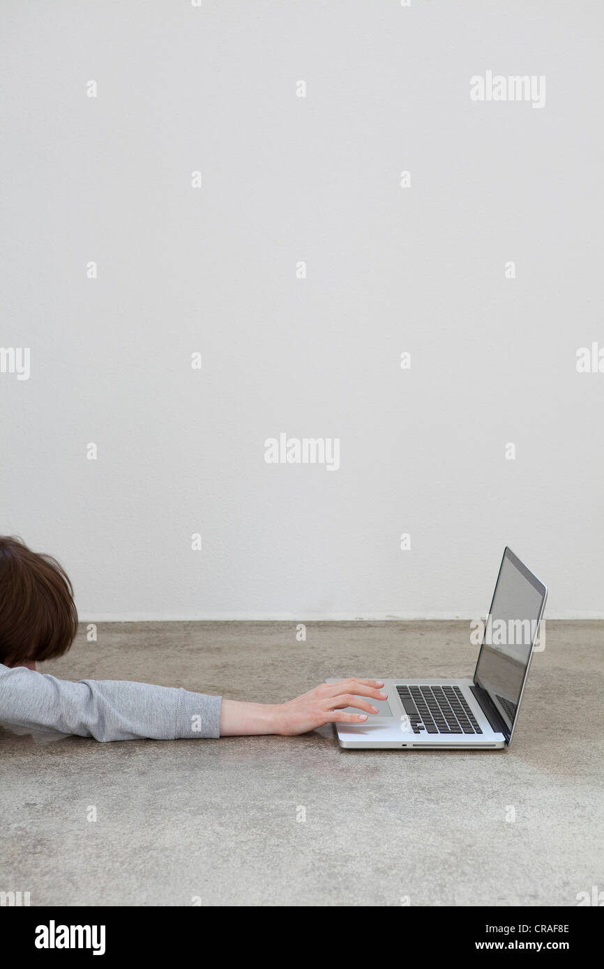 Woman reaching for a laptop, effort Stock Photo - Alamy
