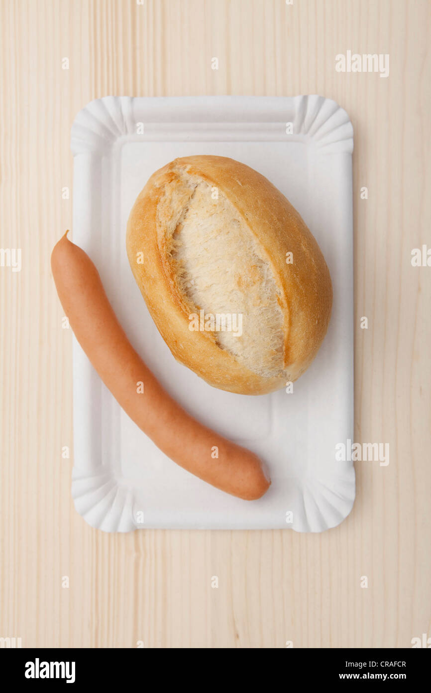Roll with sausage on paper plate, fast food Stock Photo - Alamy