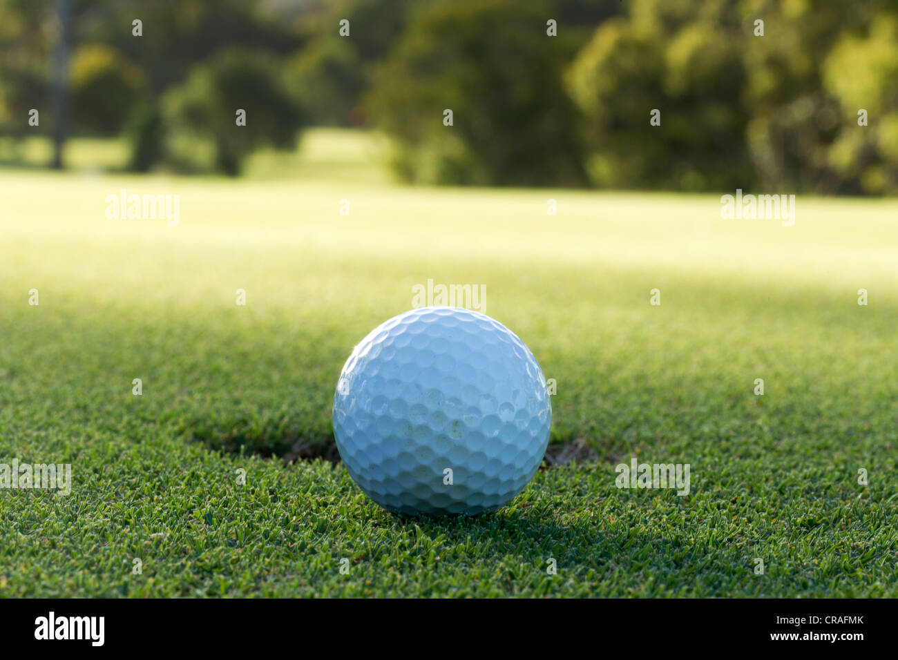 A golf ball and hole Stock Photo - Alamy