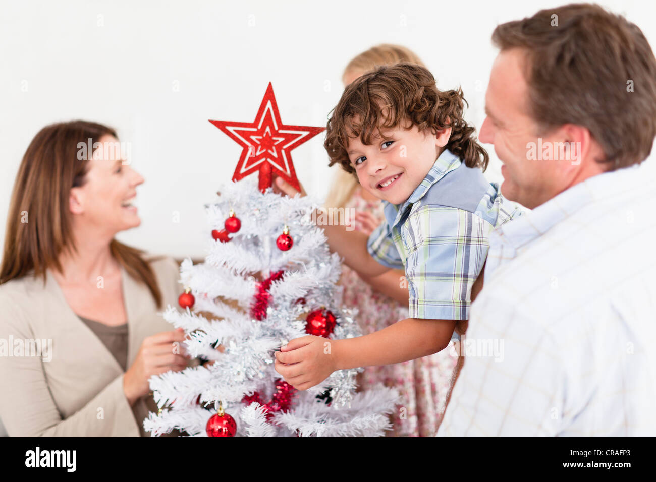 Family decorating Christmas tree Stock Photo - Alamy
