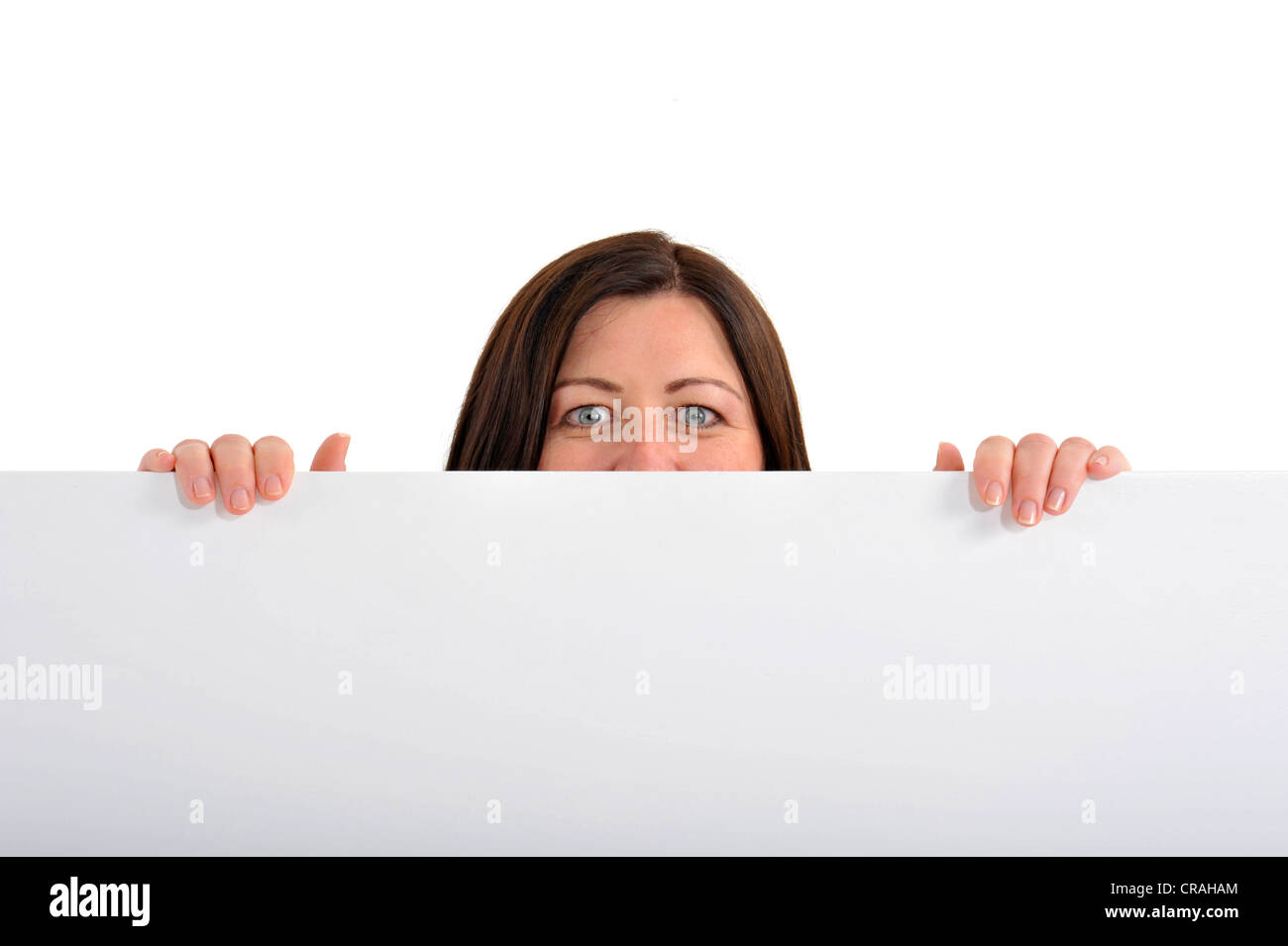 Young businesswoman looking out from behind table Stock Photo - Alamy