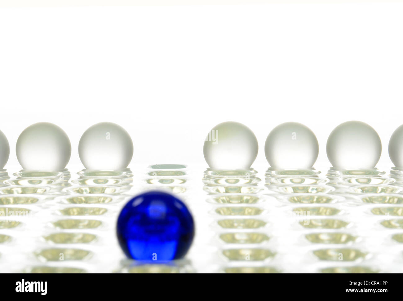 A blue ball in front of a row of white balls, symbolic image for being ...