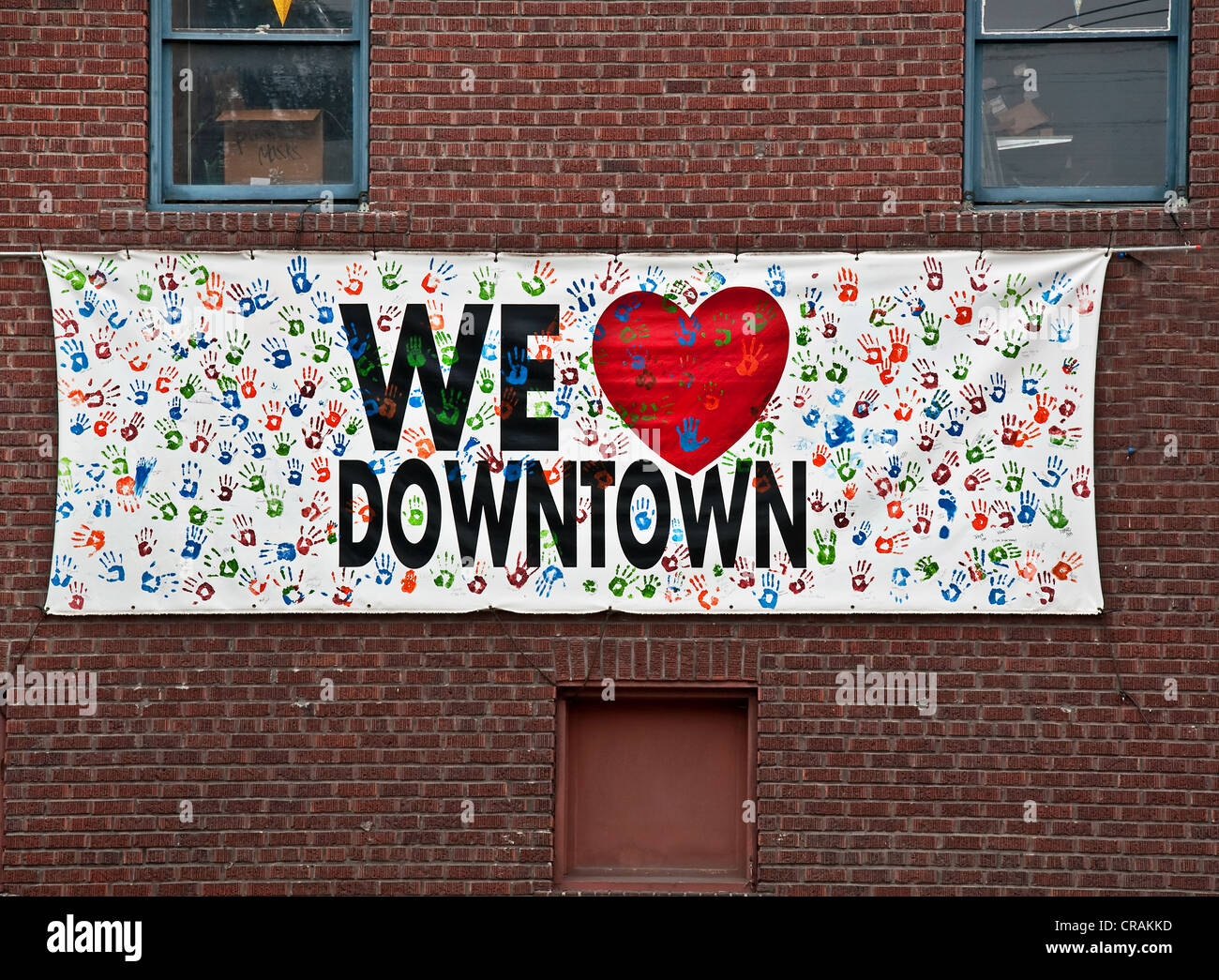 This sign with handprints all over says We Love Downtown with a heart ...