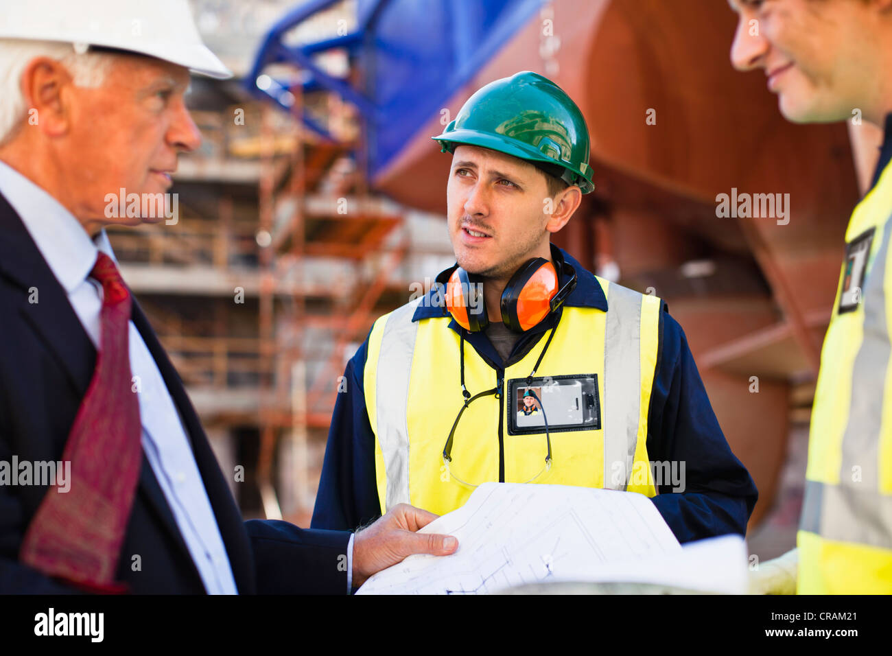 Workers reading blueprints on dry dock Stock Photo - Alamy