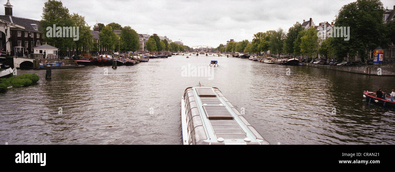 Elevated shot of an Amsterdam canal with a canal bus in the foreground ...