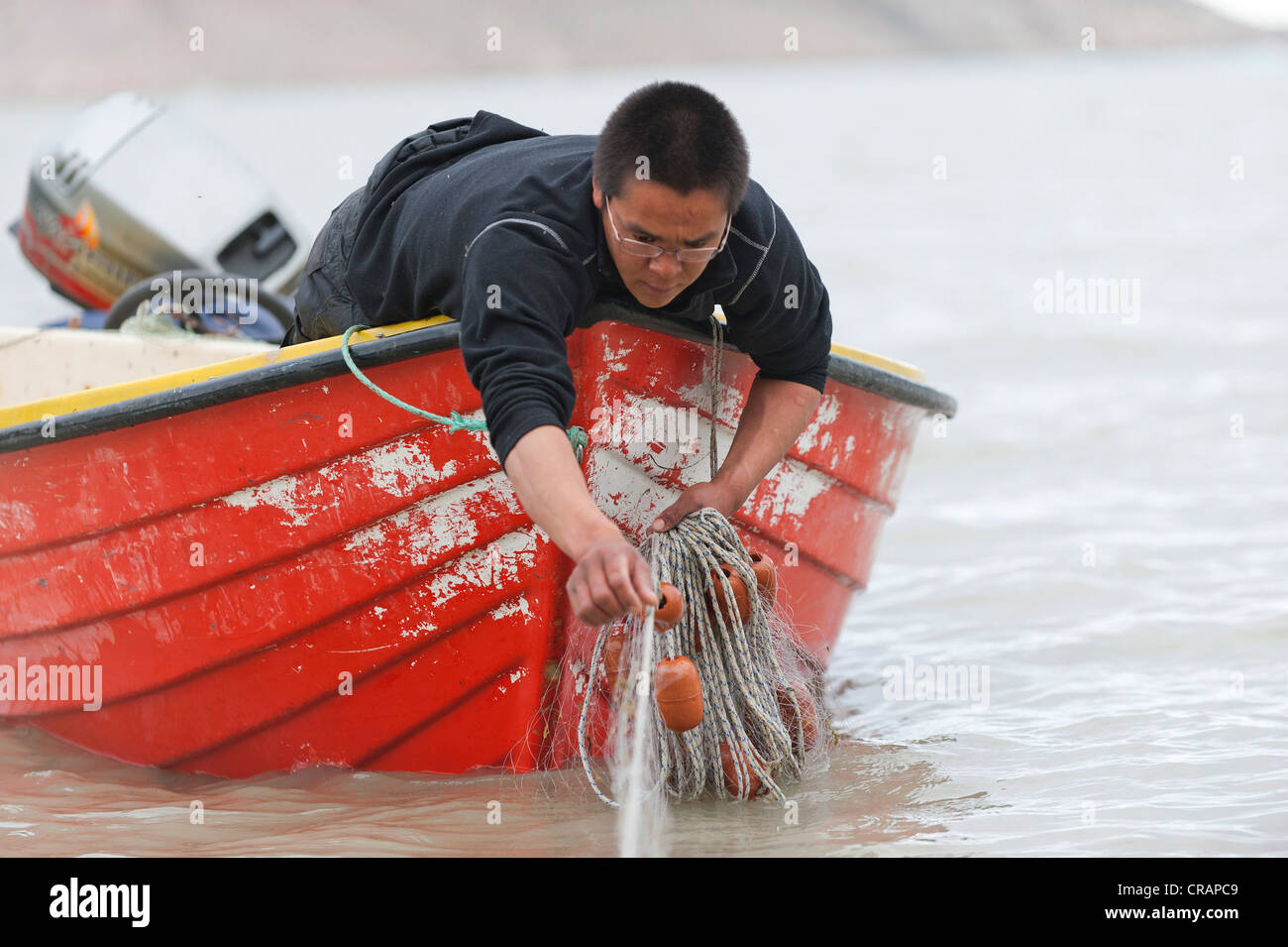 Inuit hunter fishing for salmon near the Inuit settlement of ...