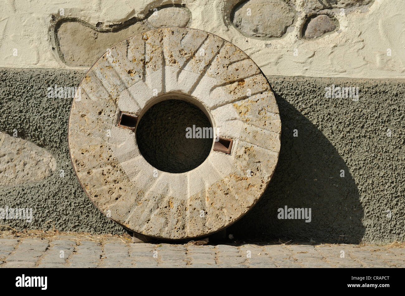 A millstone leaning against a wall, Germany, Europe Stock Photo - Alamy