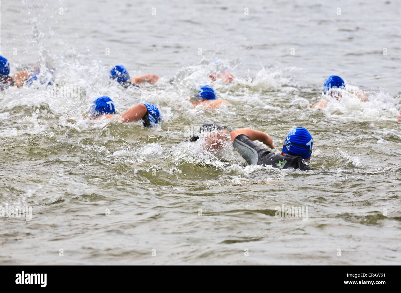 Triathlon swimmers entering water for competition Stock Photo - Alamy