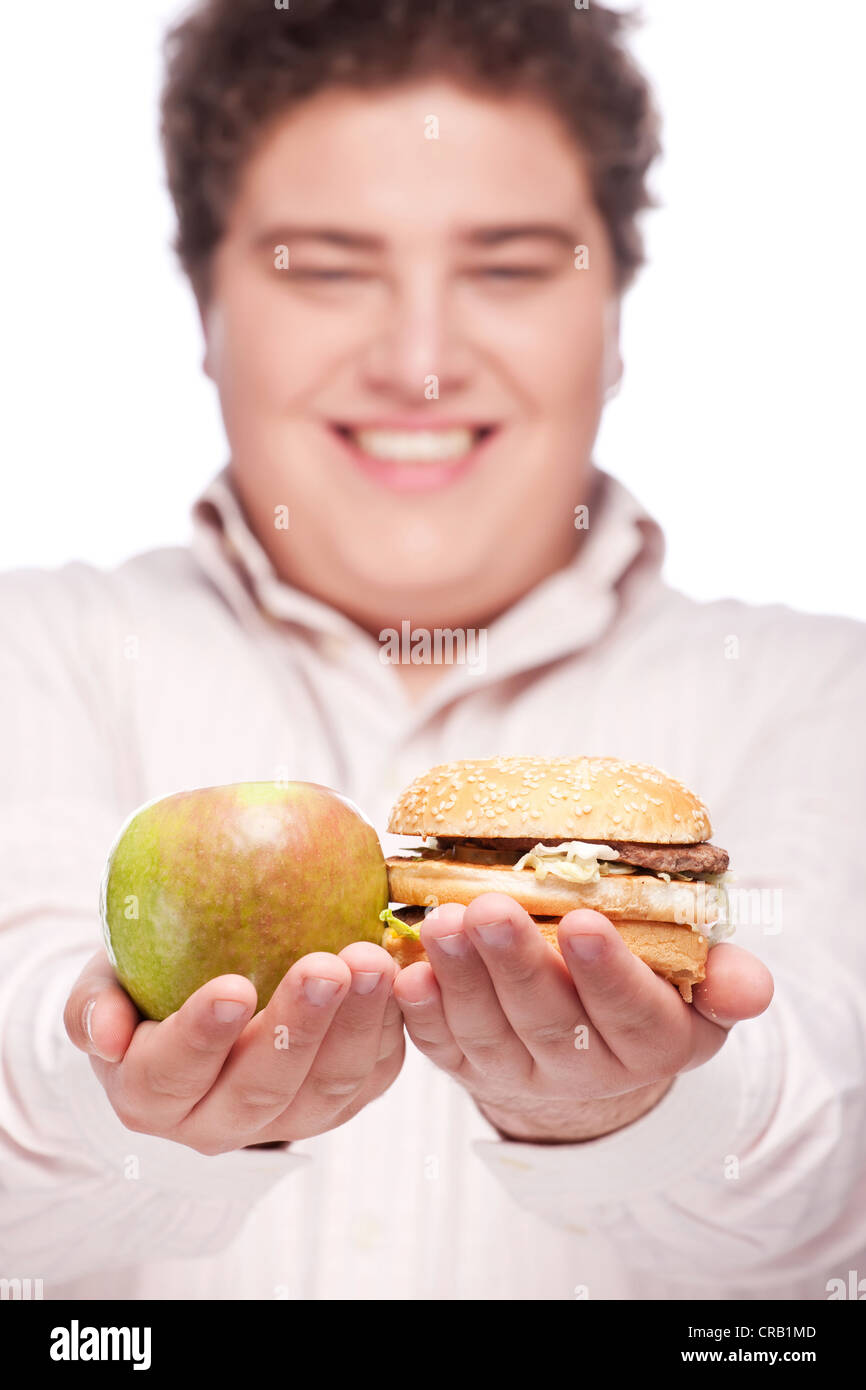 apple and hamburger in hands of a young chubby man, isolated on white ...