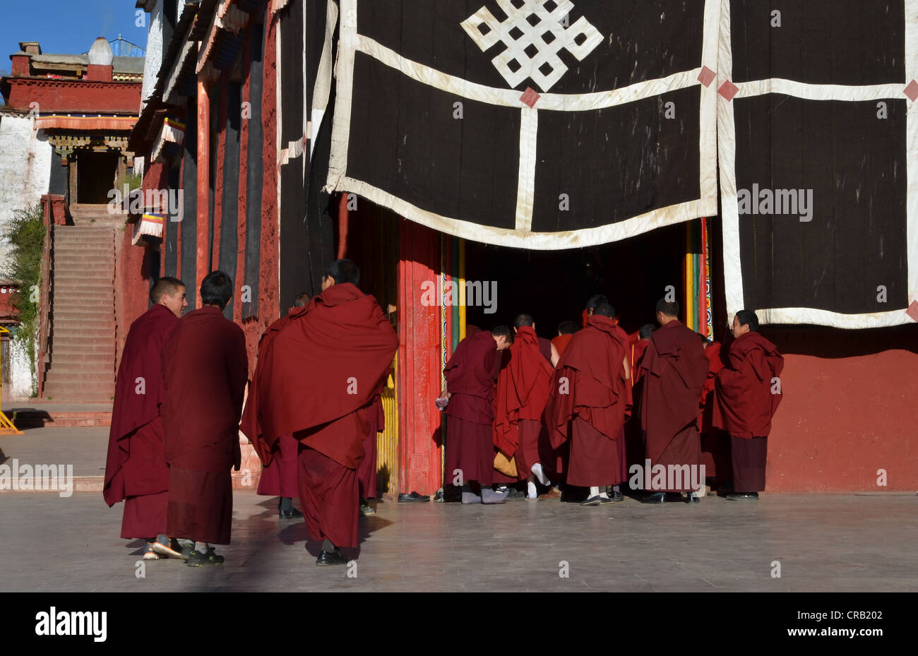 Tibetan monks wearing red monk's robe upon entering the meeting hall of ...