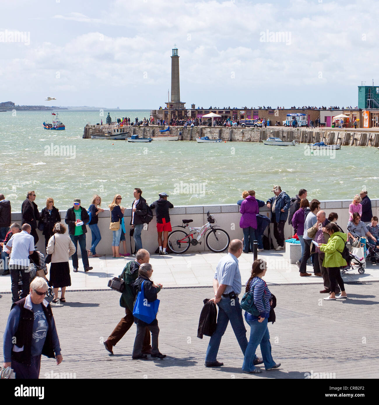 Crowds enjoying a windy but sunny day on Margate seafront. Kent England ...
