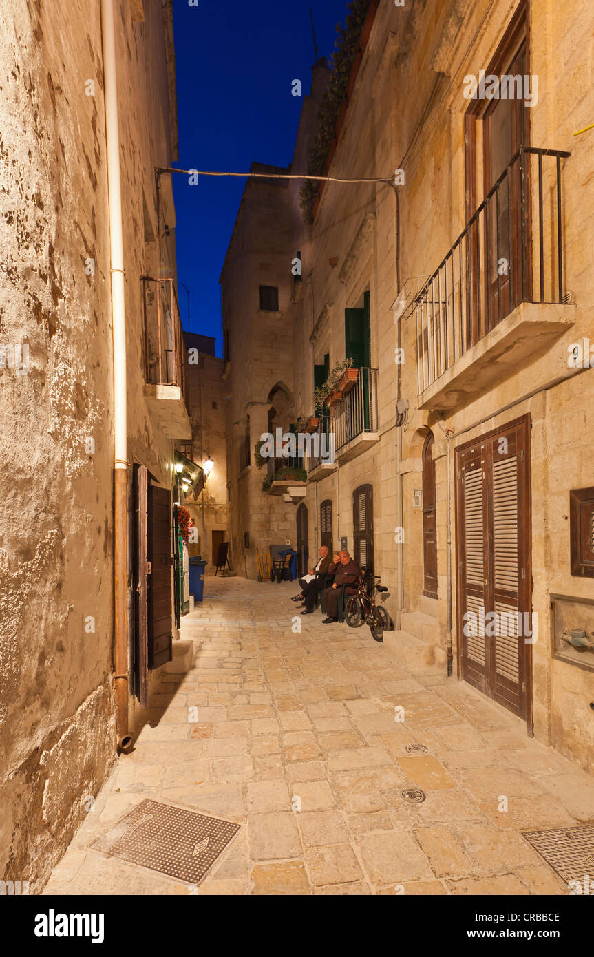 Alleyway in the historic district of Polignano a Mare, old people ...