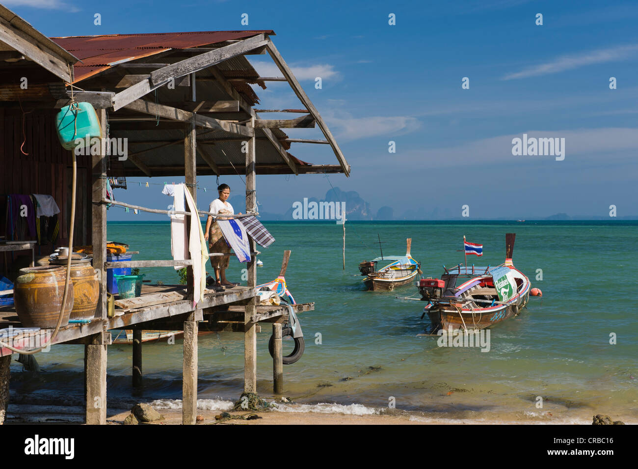 Woman on a stilt house in the fishing village, Ko Muk or Ko Mook island ...