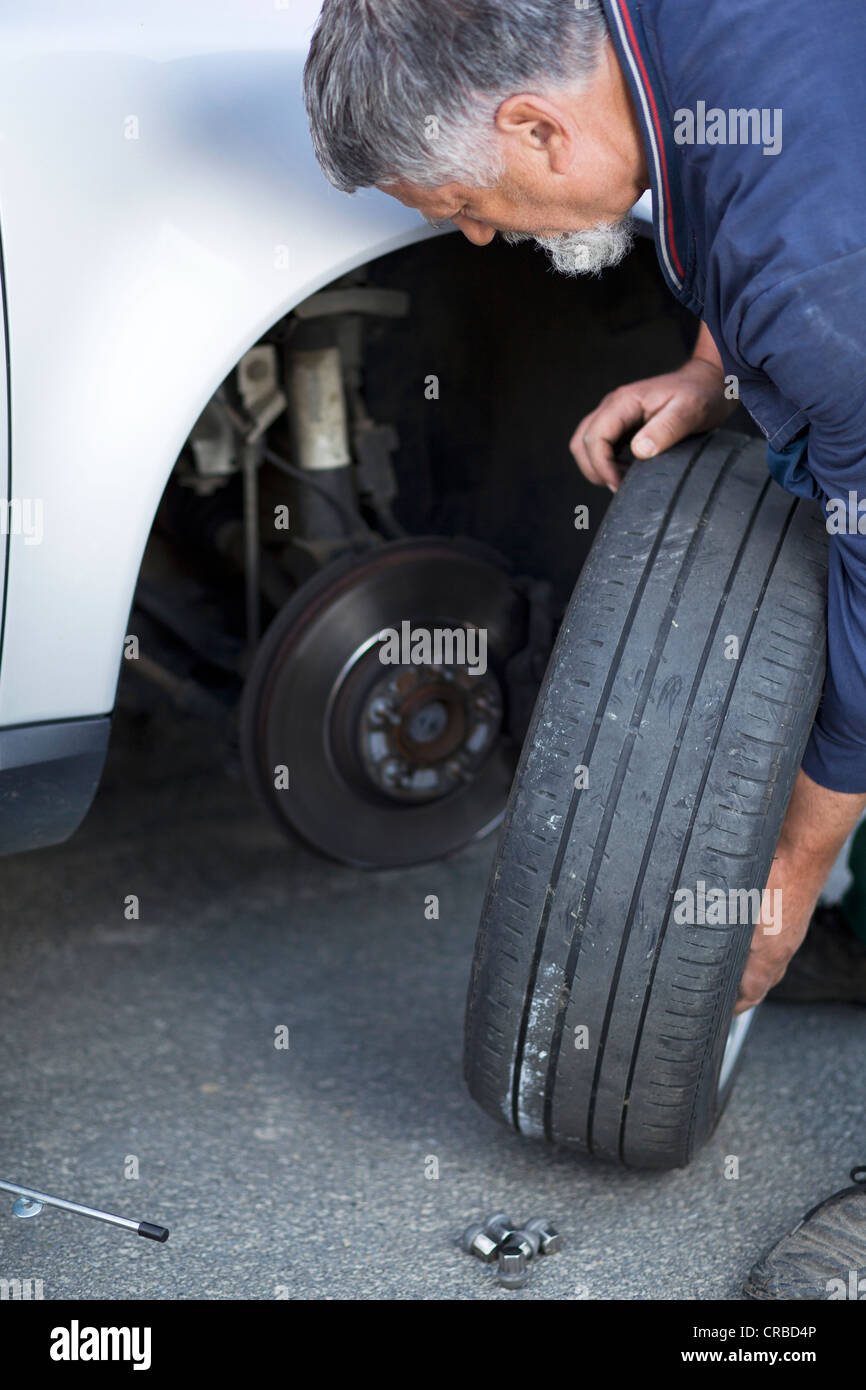 mechanic changing a wheel of a modern car (color toned image Stock ...