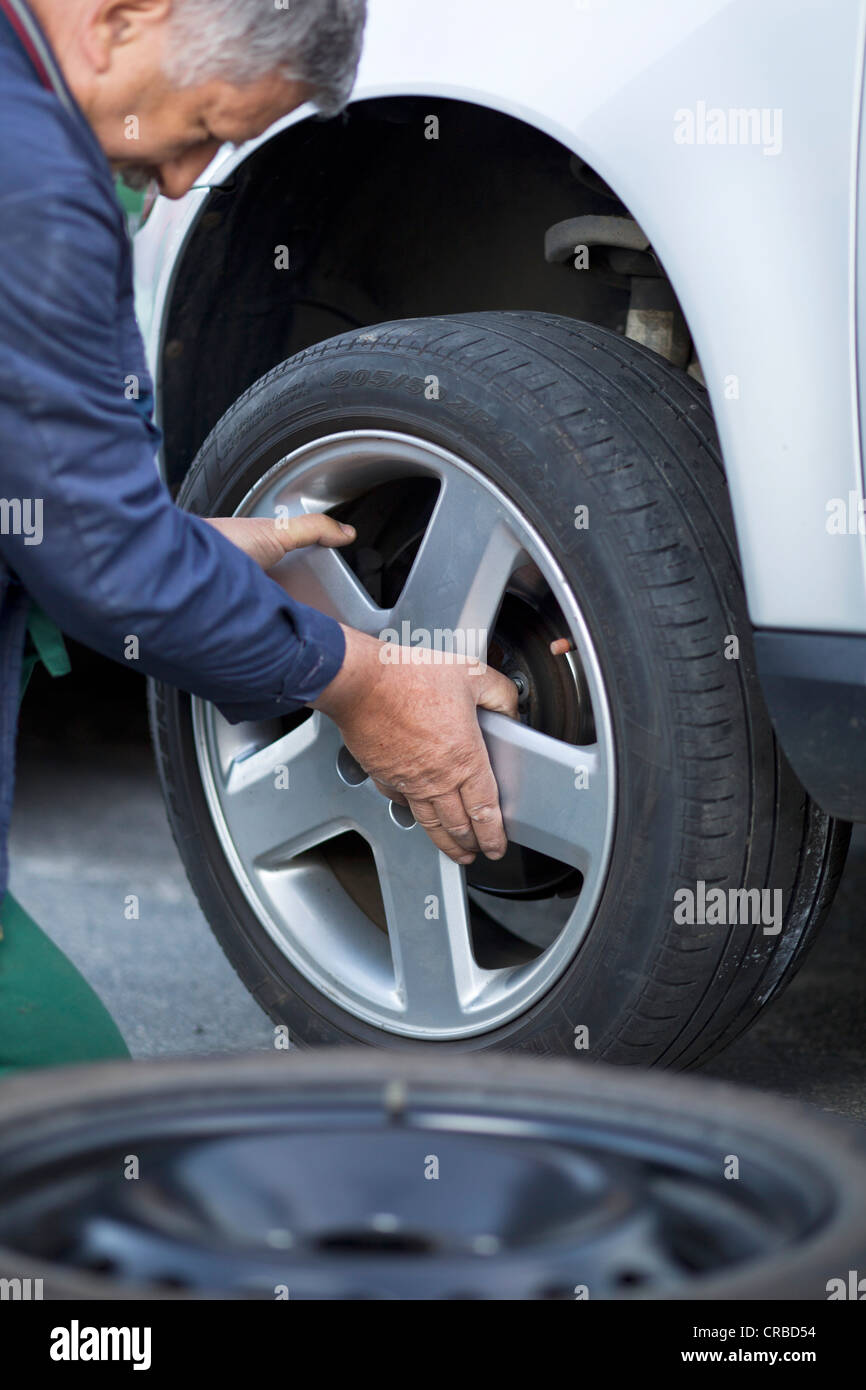 mechanic changing a wheel of a modern car (color toned image Stock ...