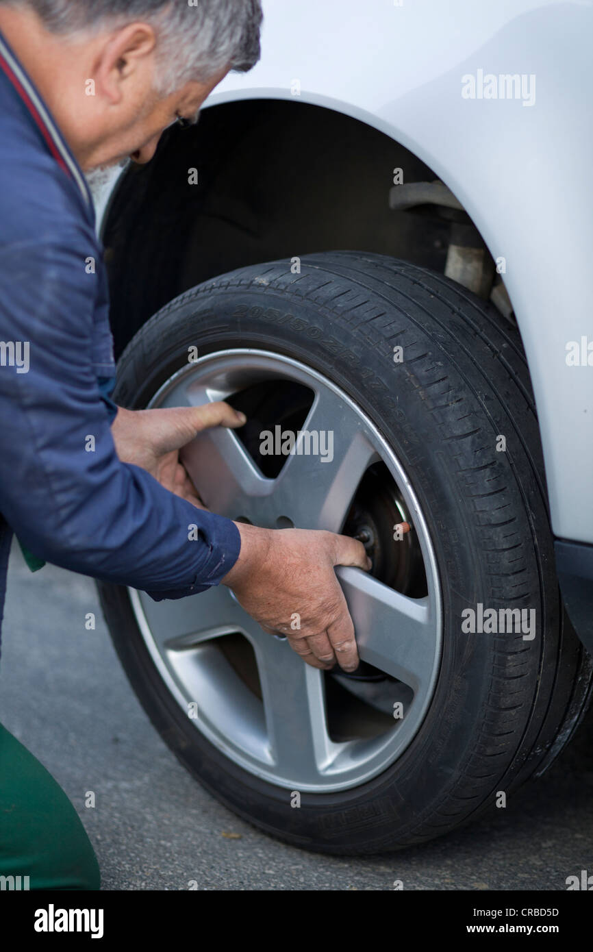 mechanic changing a wheel of a modern car (color toned image Stock ...