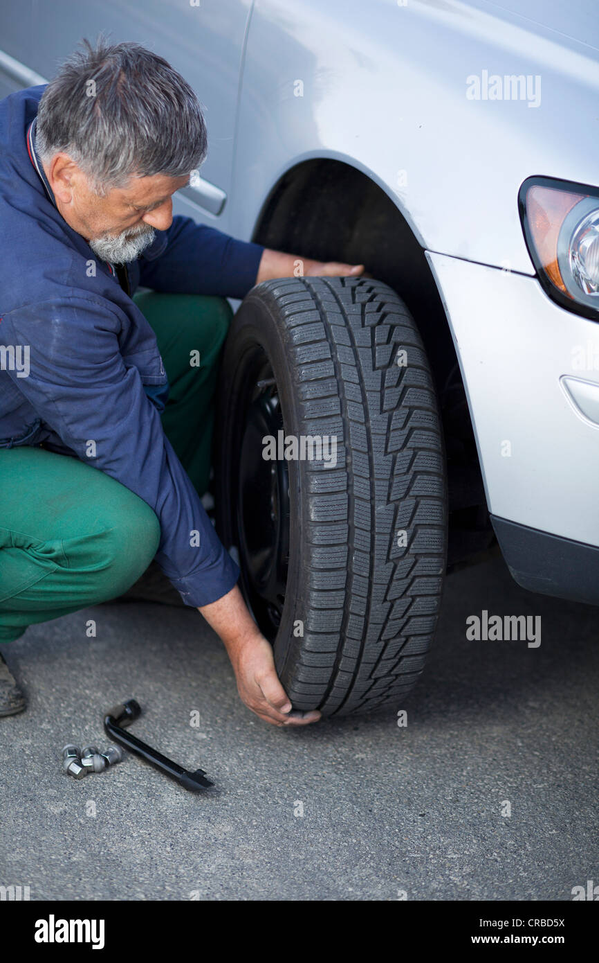 mechanic changing a wheel of a modern car (color toned image Stock ...
