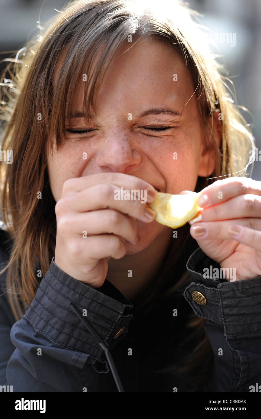 Young woman biting into lemon and laughing, Paris, France, Europe Stock ...