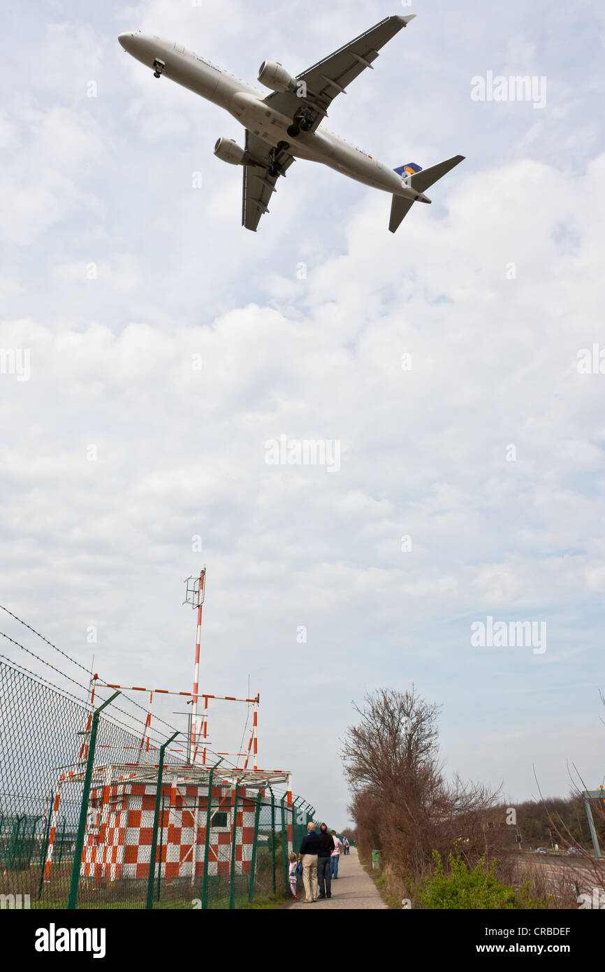 Plane approaching the airport flying over the heads of walkers ...