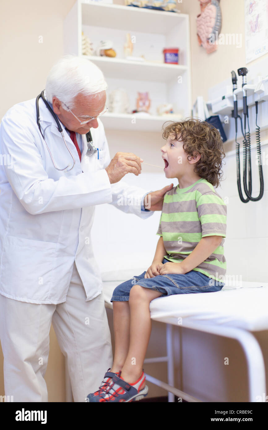 Doctor examining boy in office Stock Photo - Alamy