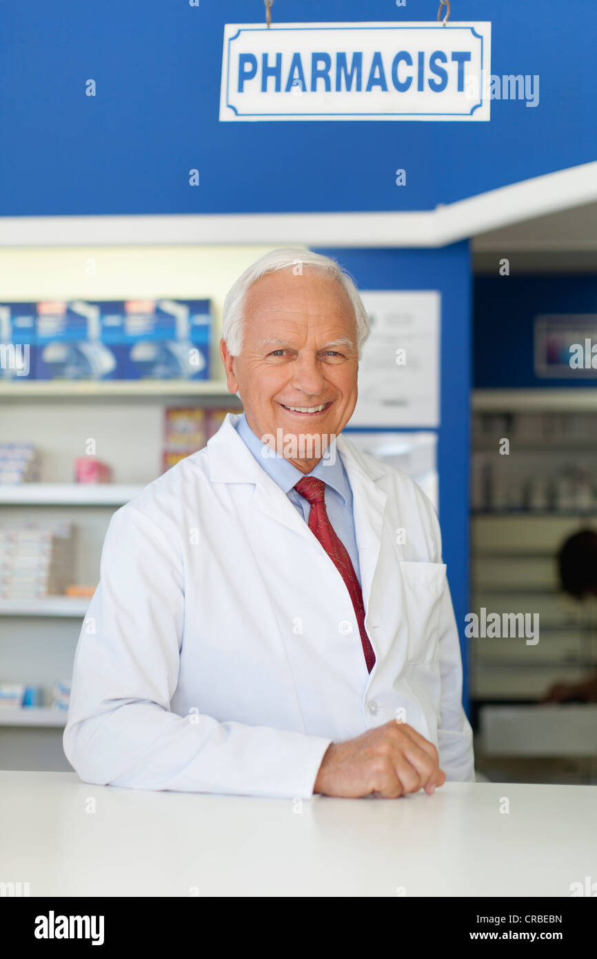 Pharmacist smiling at counter Stock Photo - Alamy
