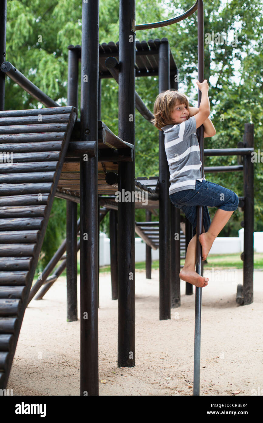 Boy playing on play structure Stock Photo - Alamy