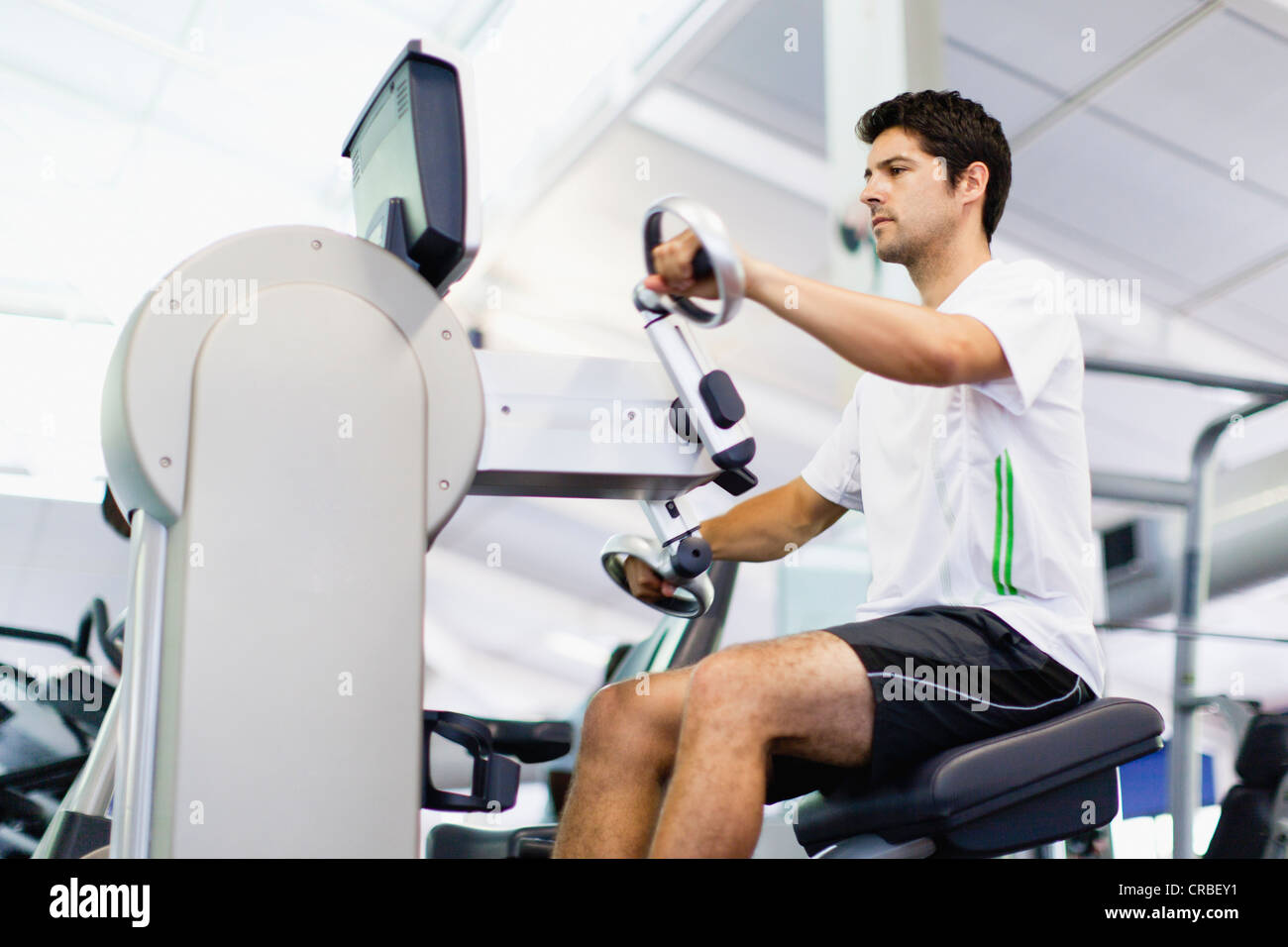 Man using exercise machine in gym Stock Photo - Alamy
