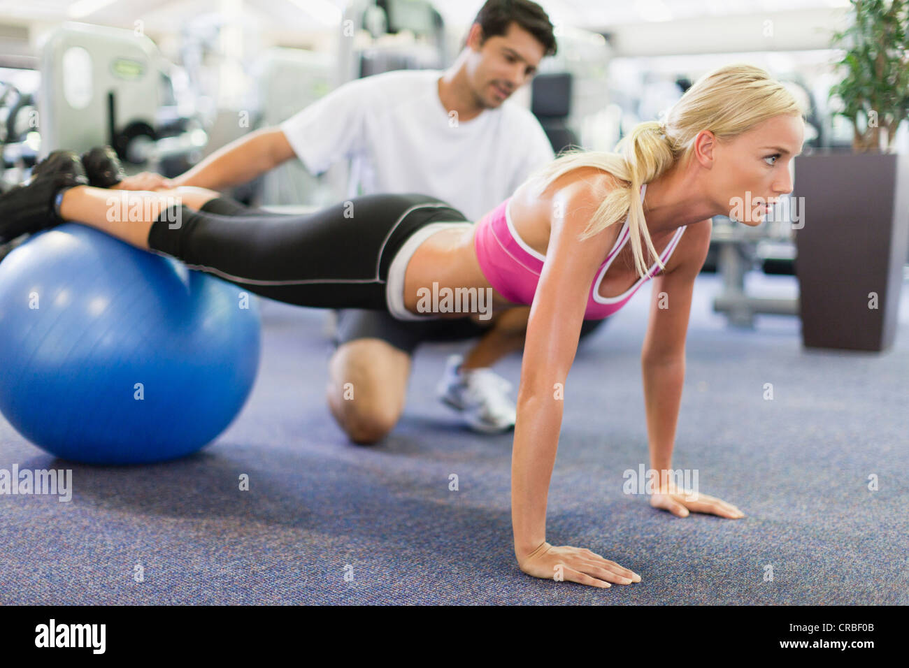 Woman working with trainer in gym Stock Photo - Alamy
