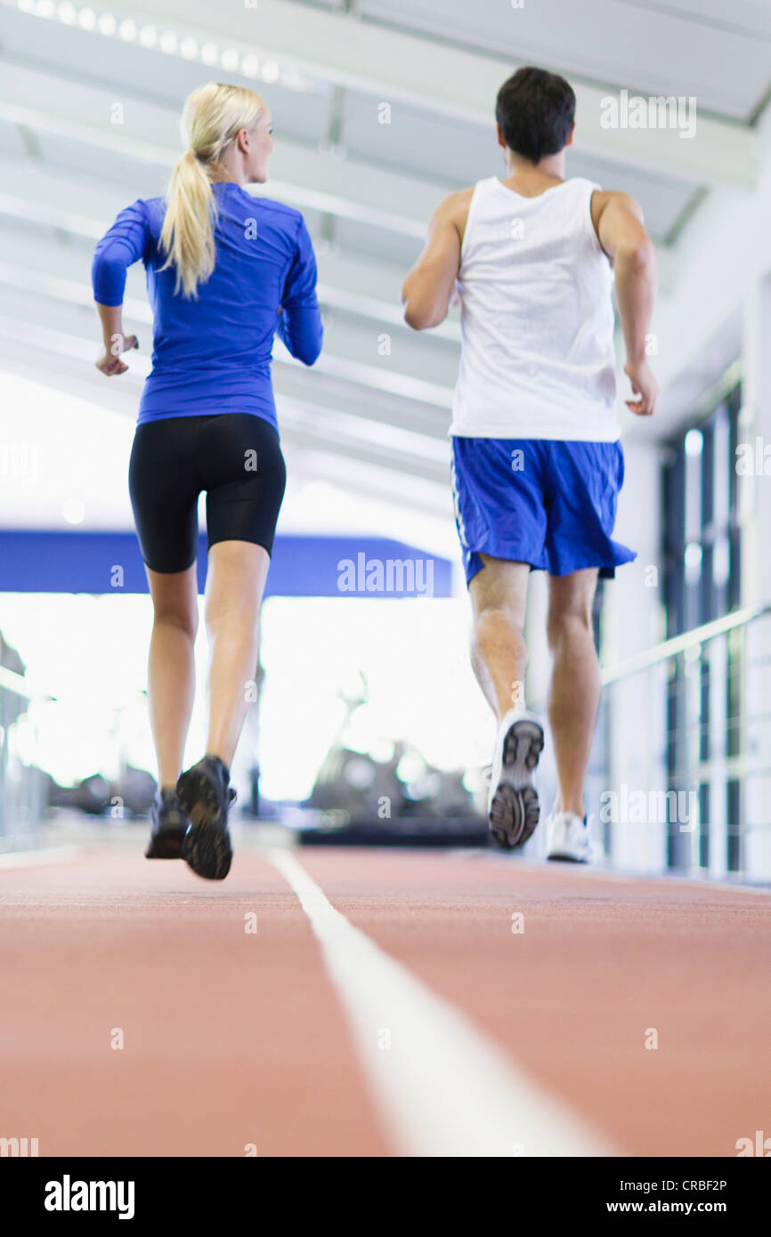 Couple running on indoor track in gym Stock Photo - Alamy