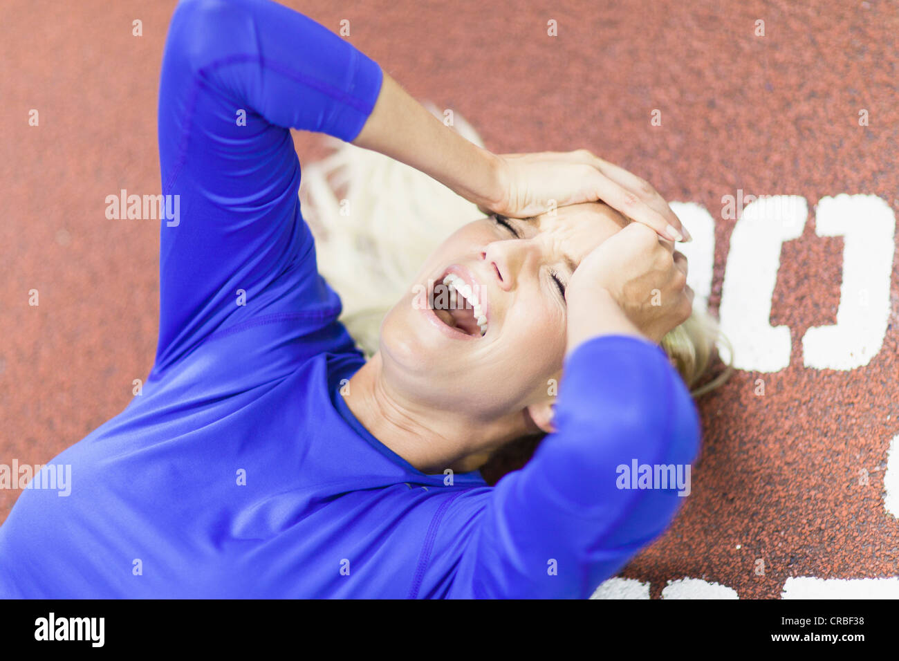 Woman shouting on indoor track in gym Stock Photo - Alamy