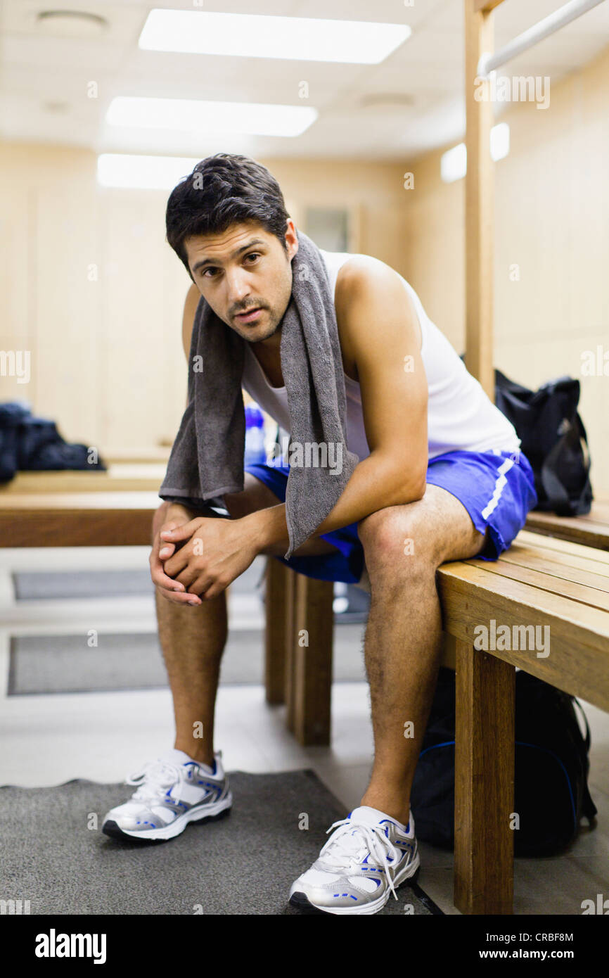 Man resting on locker room bench Stock Photo - Alamy