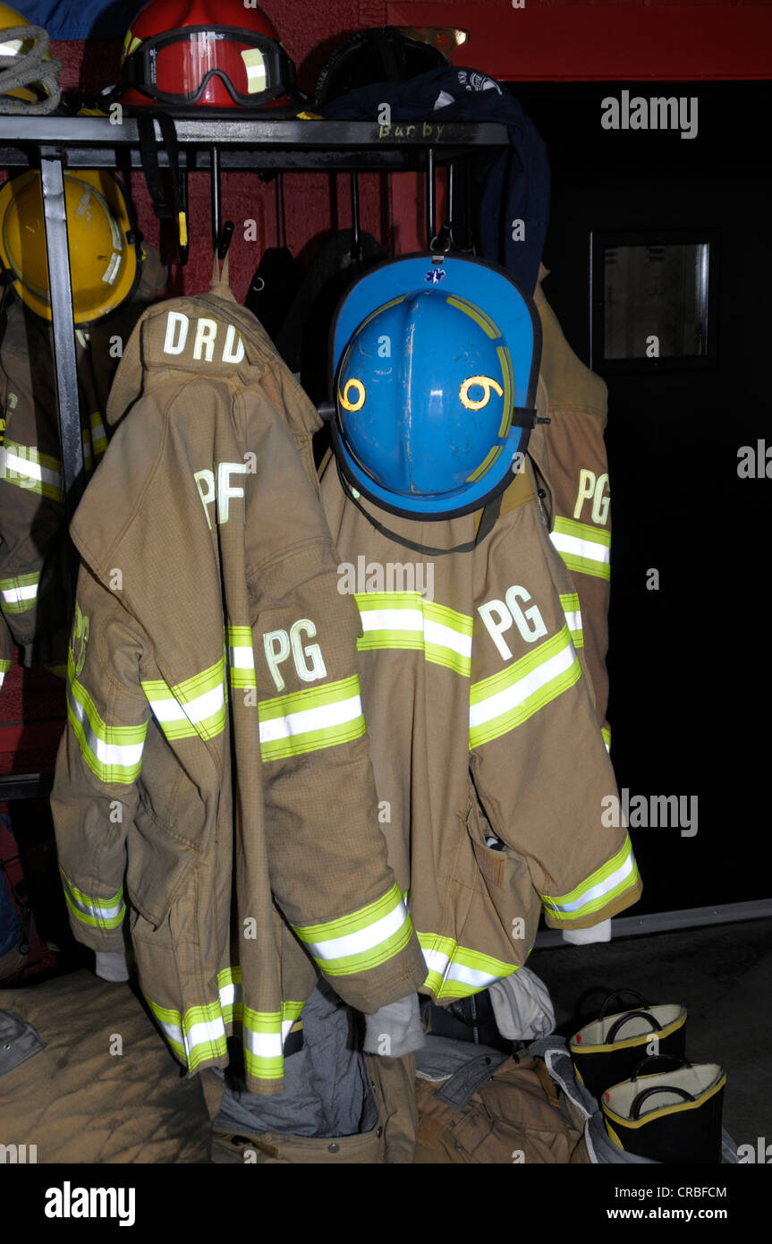 firefighters turnout gear hanging on a wall in a firehouse in ...