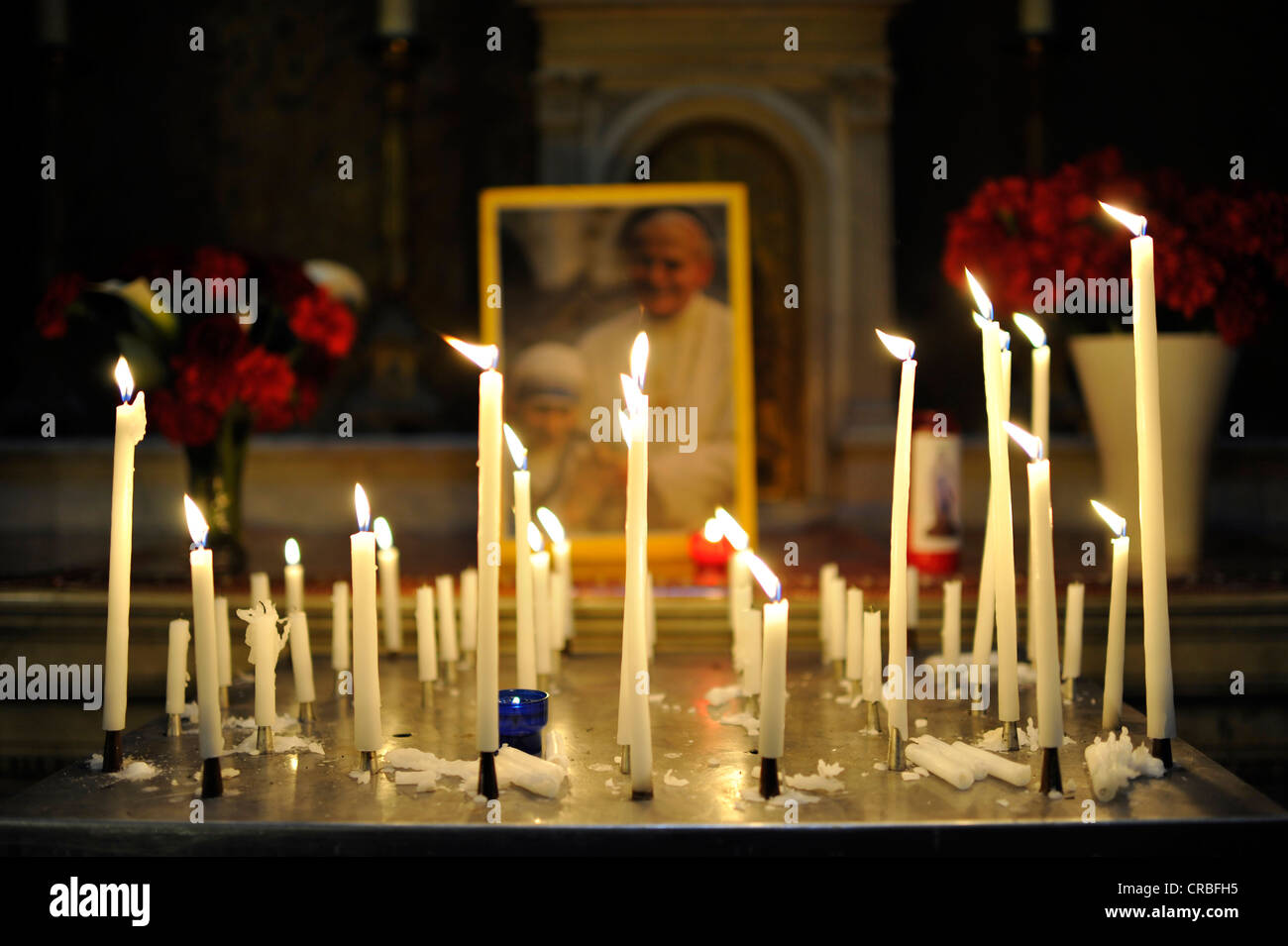 Votive candles in front of a photo of Pope John Paul II with Mother ...