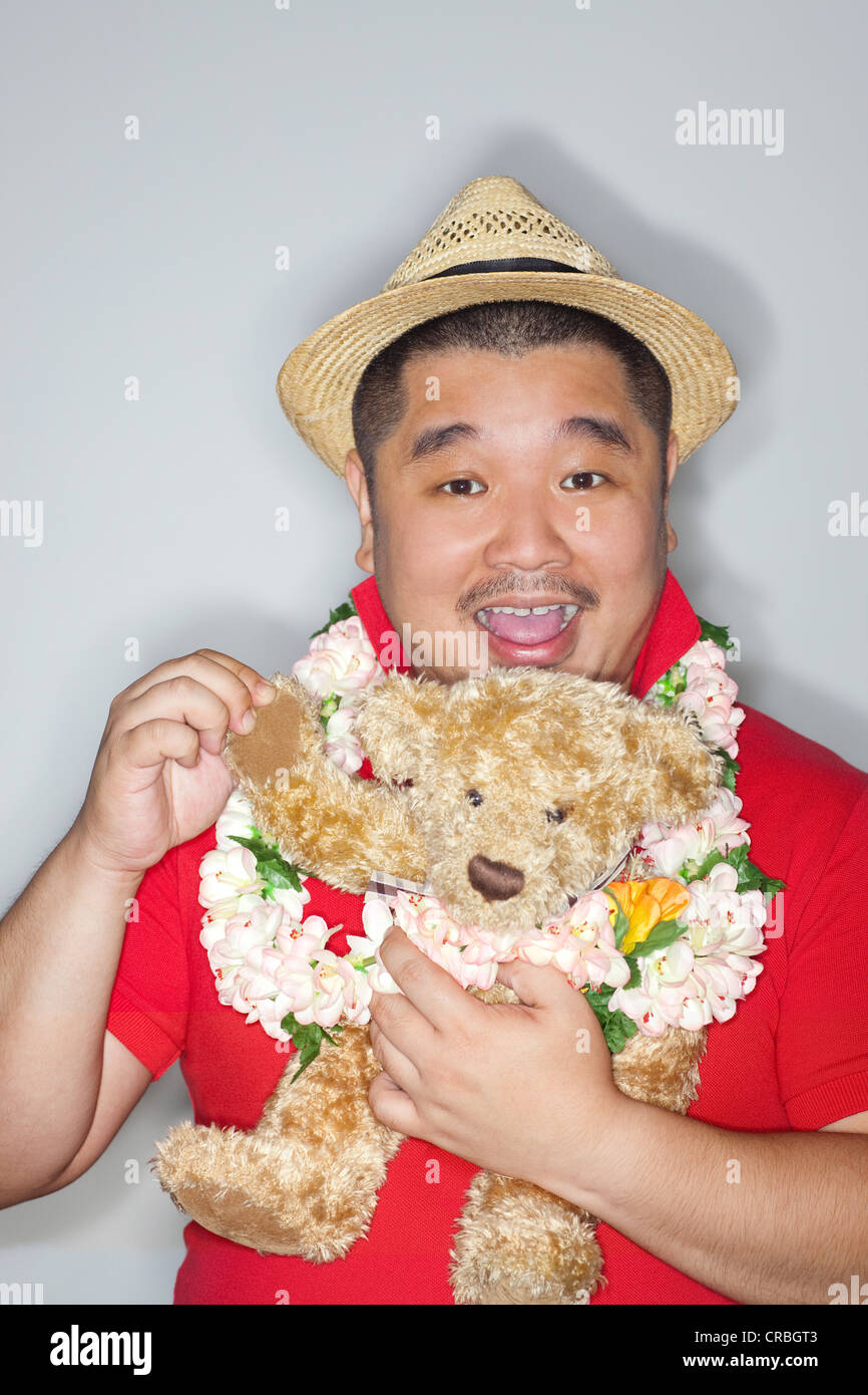Portrait of a cheerful man with garland and teddy bear Stock Photo - Alamy