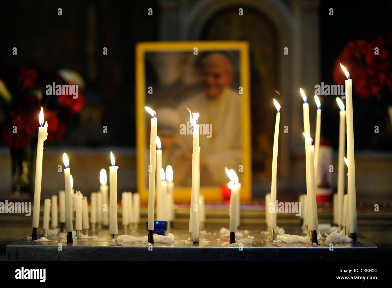 Votive candles in front of a photo of Pope John Paul II with Mother ...