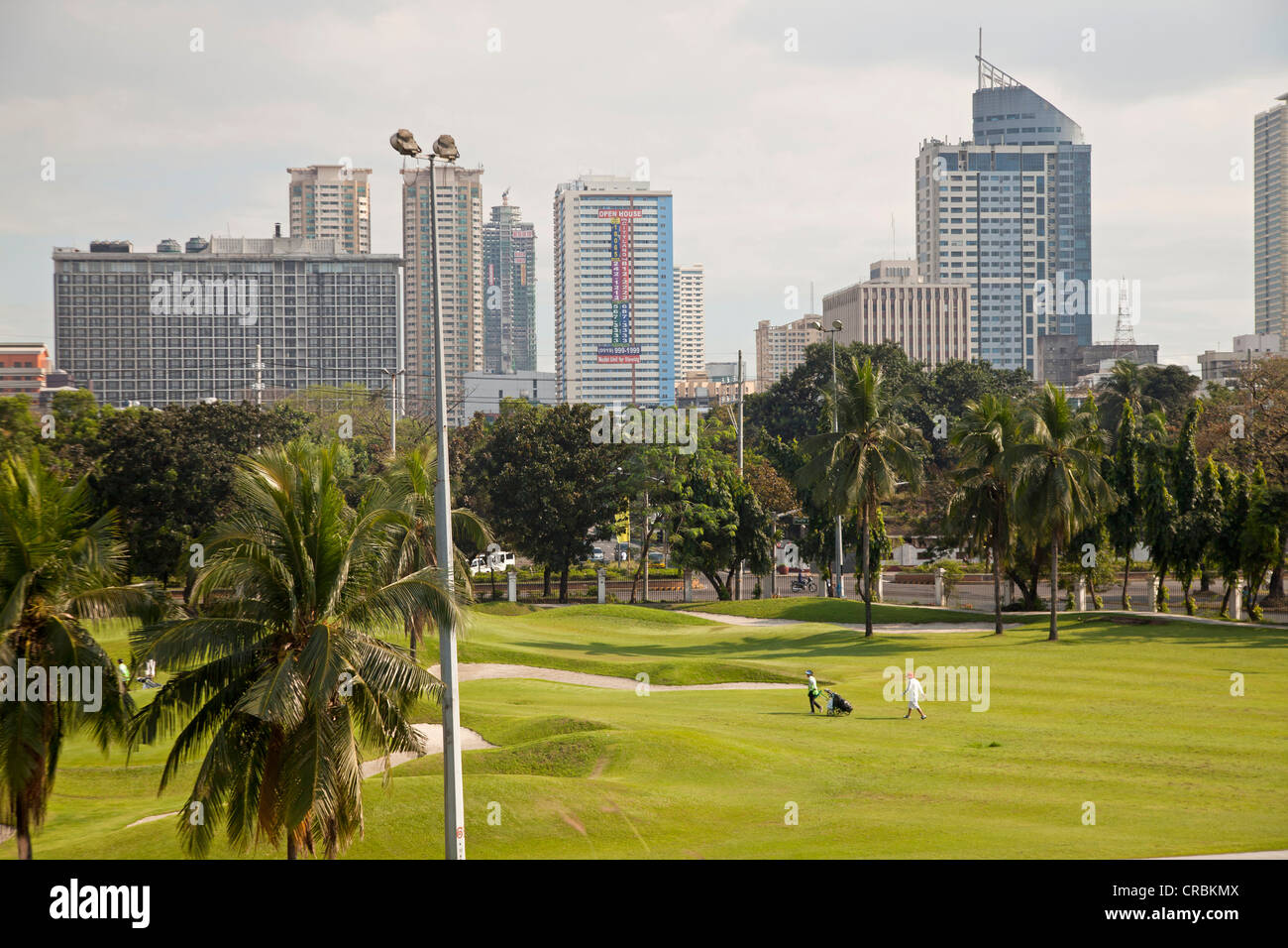 Golf course in the town centre with the skyline of Manila, Philippines ...