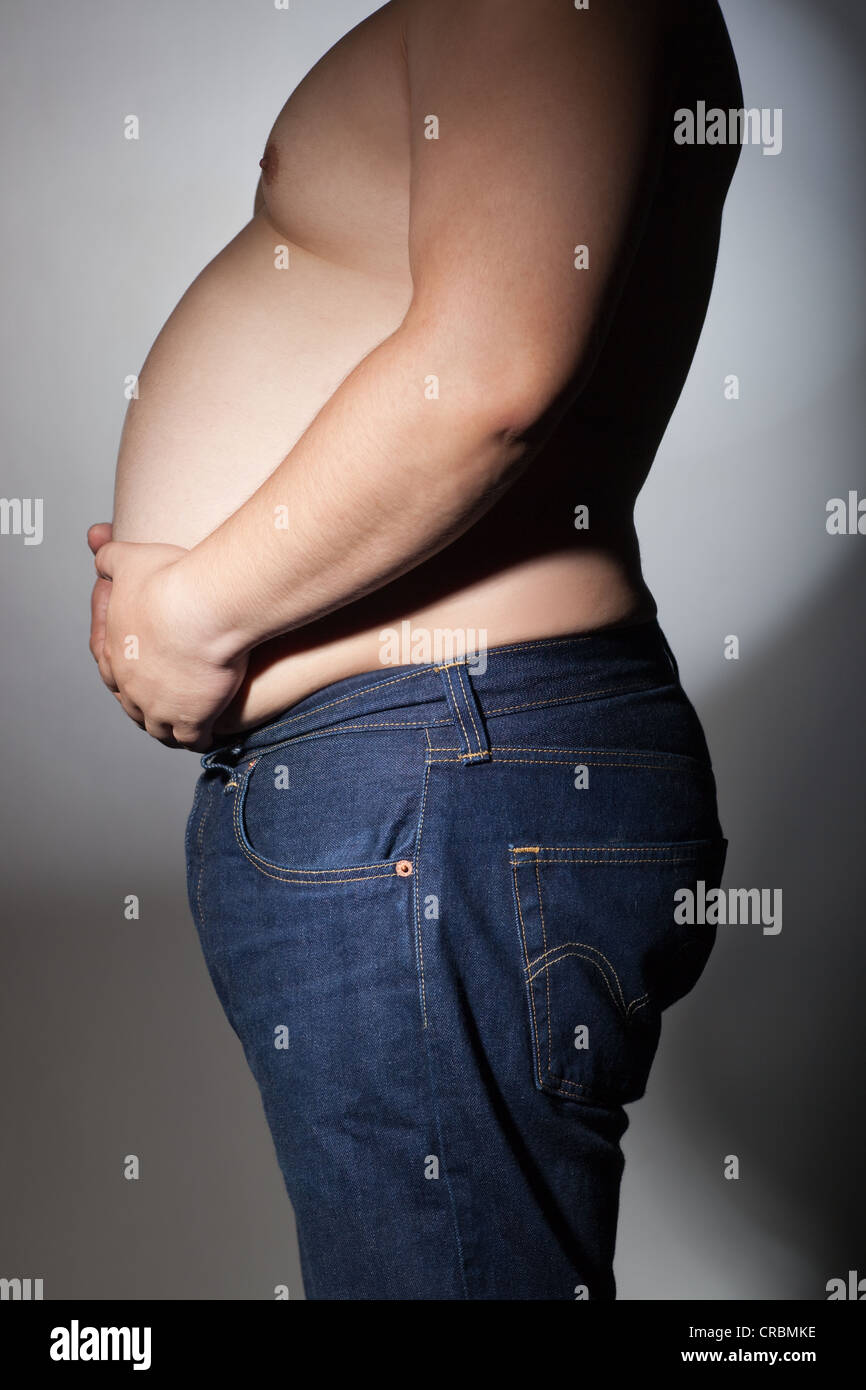 Midsection of a man holding his belly fat Stock Photo - Alamy