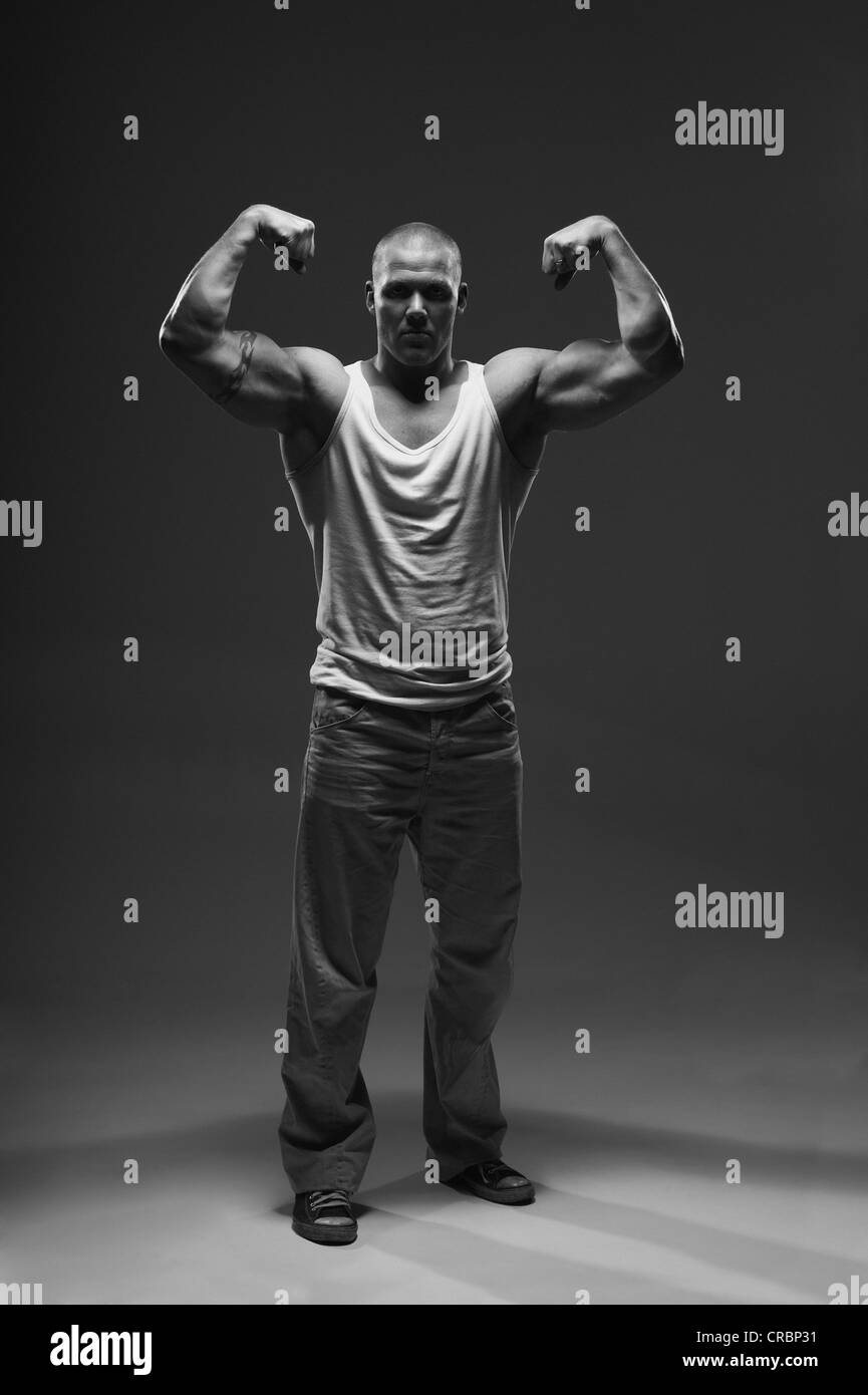 Athlete displaying arm muscles indoors Stock Photo - Alamy