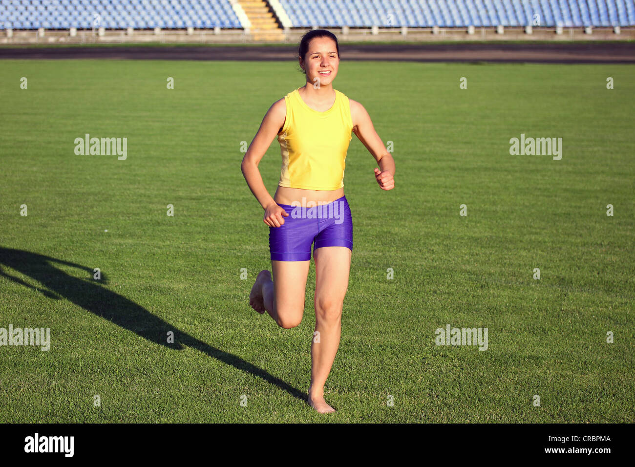 Beautiful teenage sport girl running on the grass active hi-res stock ...