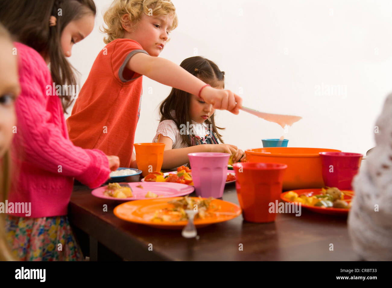 Children eating together at table Stock Photo - Alamy