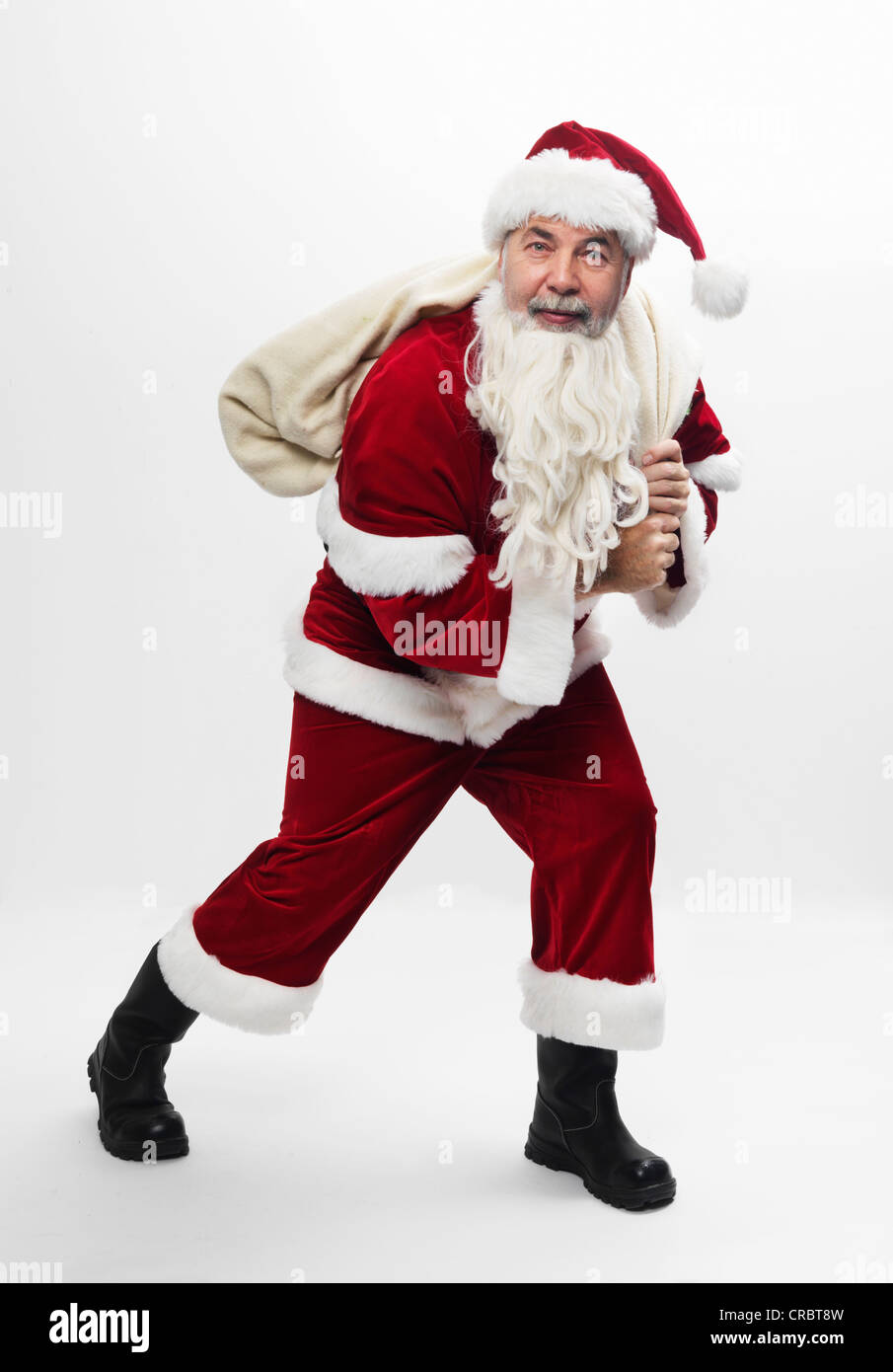 Santa carrying sack of Christmas gifts Stock Photo - Alamy
