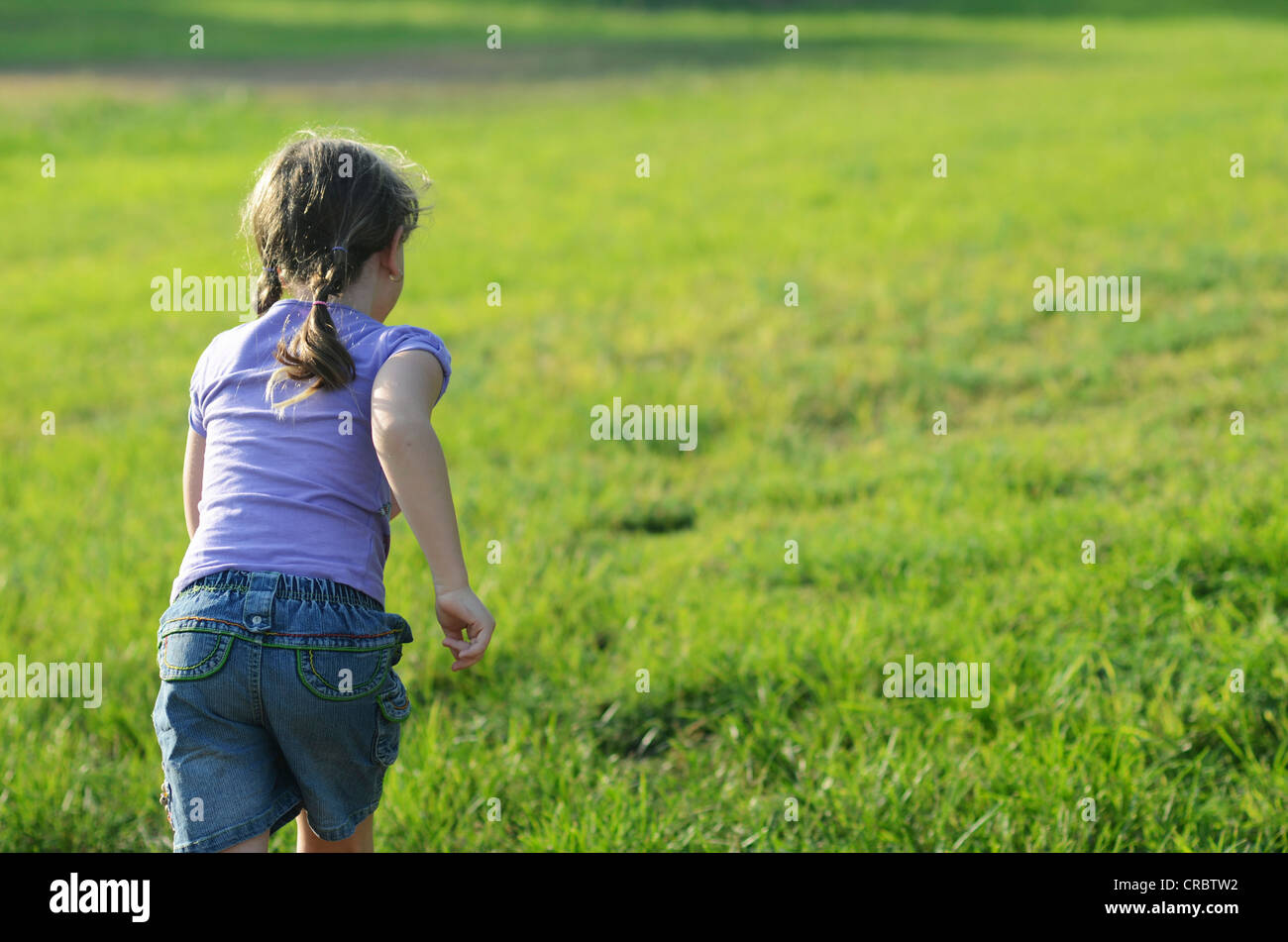 Girl running in rural meadow Stock Photo - Alamy