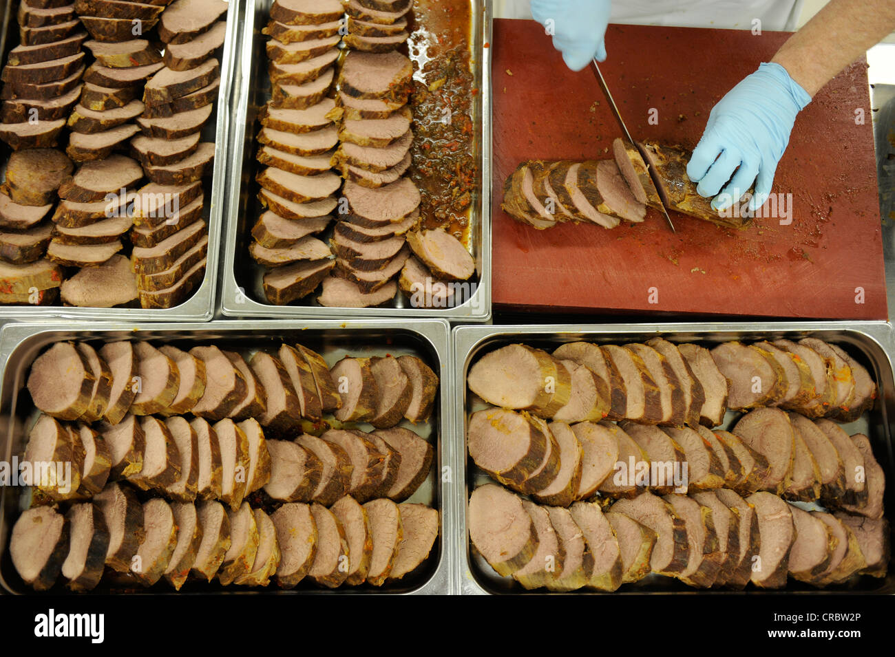 Meat being cut by hand in a commercial kitchen Stock Photo - Alamy