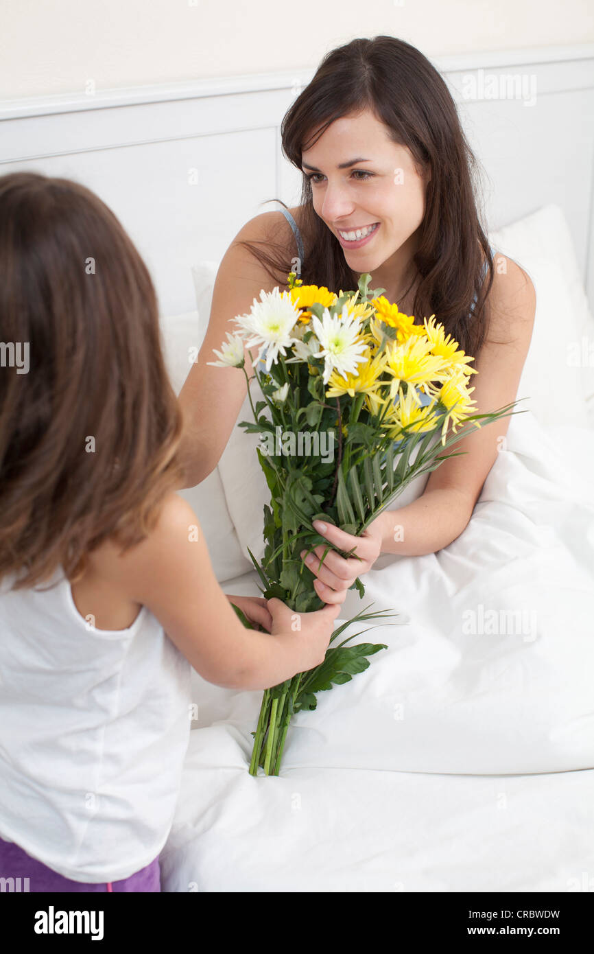 Girl bringing mother bouquet of flowers Stock Photo - Alamy