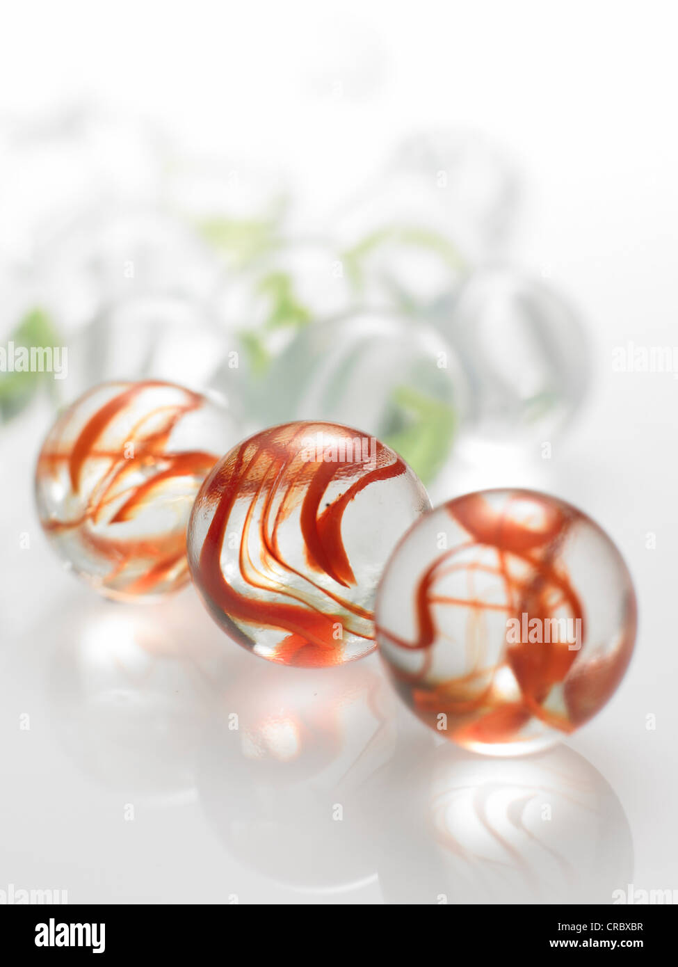 3 red glass marbles with a group of dull colored glass marbles in the ...