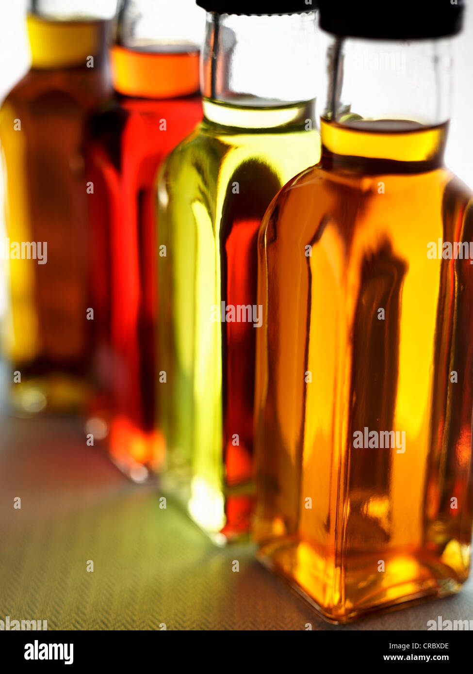 a selection of colored cooking oils in a row portrait Stock Photo - Alamy