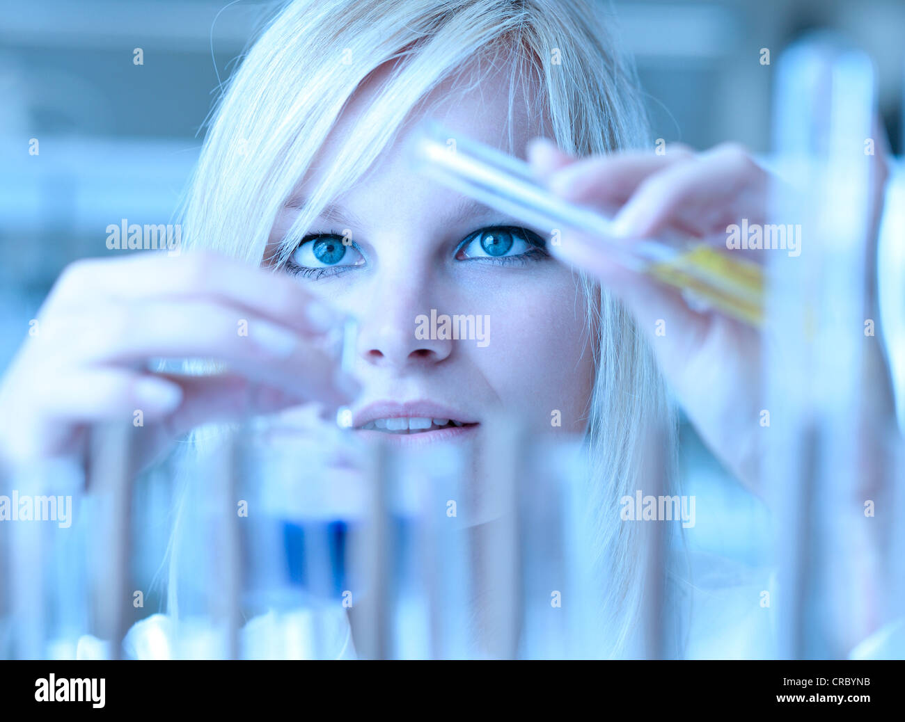 Closeup of a female researcher holding up a test tube and a retort and ...