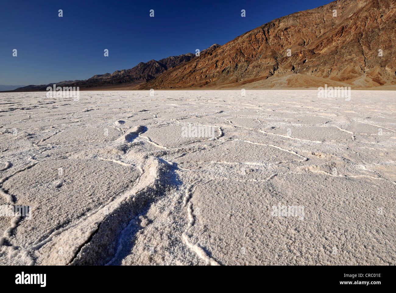 Salt pan, salt crystals, Badwater Basin, Black Mountains at back, Death ...
