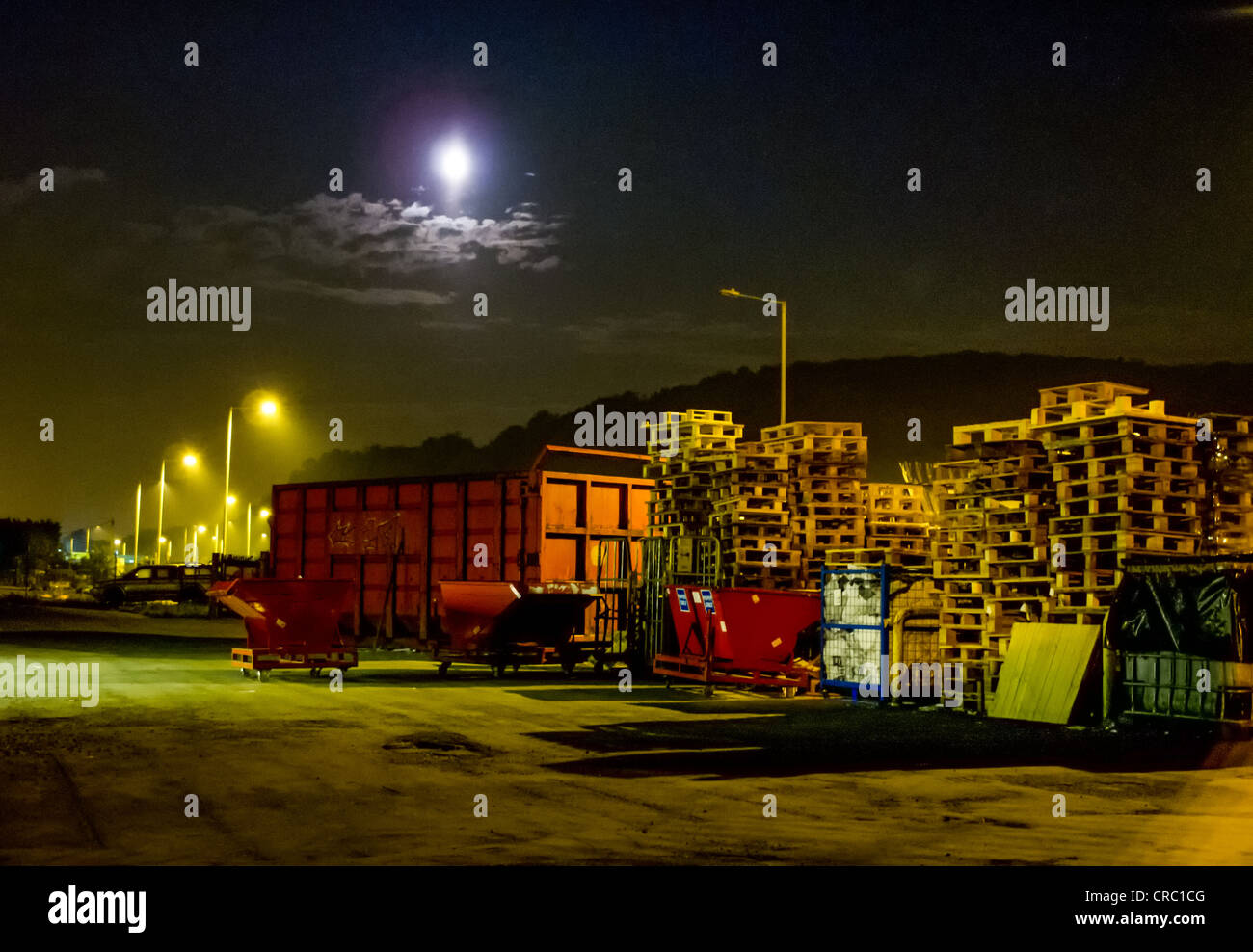 Waste bins, skips and wooden pallets in a factory yard at night Stock ...
